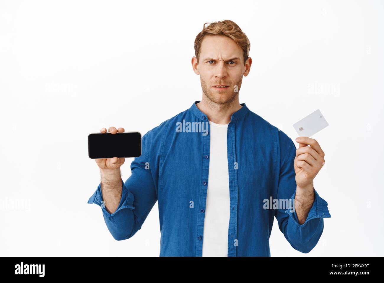 Disappointed young man shows smartphone screen flipped horizontal and ...