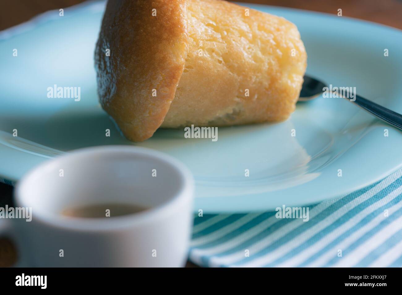 Famous Espresso and Neapolitan baba on a blue plate for a sweet snack ...