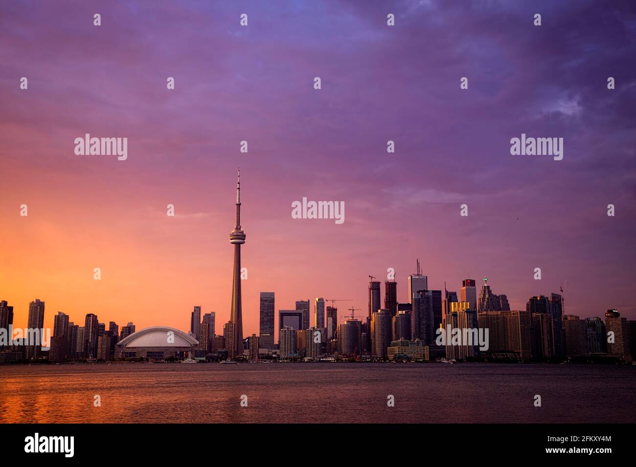 The Toronto city skyline with orange glow in the sky at sunset , seen ...