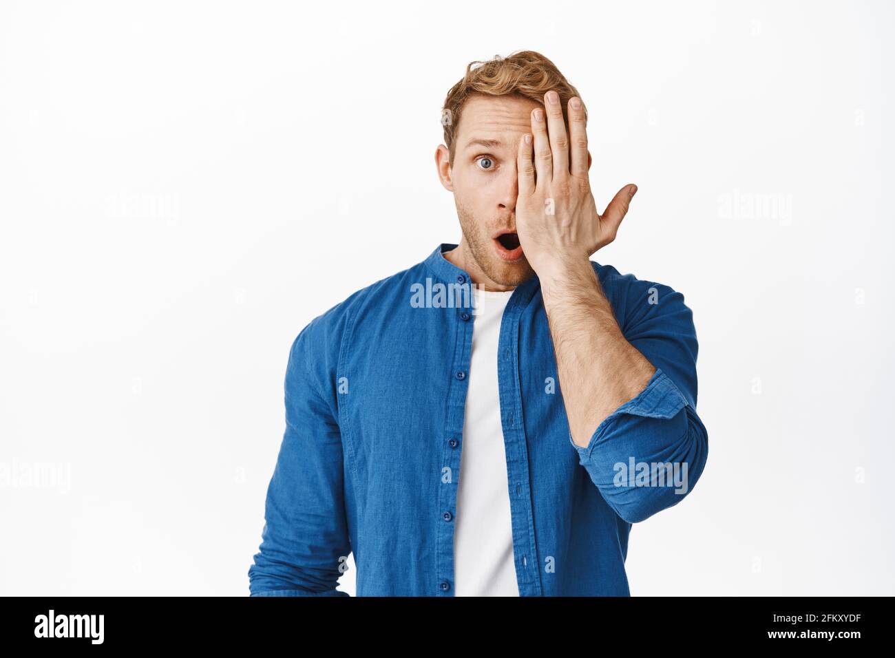 Close up of redhead male model looking with one eye side of face and ...