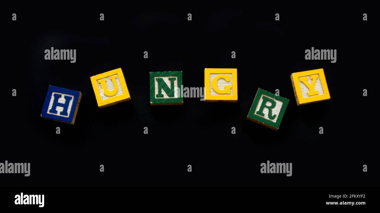 Wooden block letters spell the word hungry on a magnetic board. Image ...
