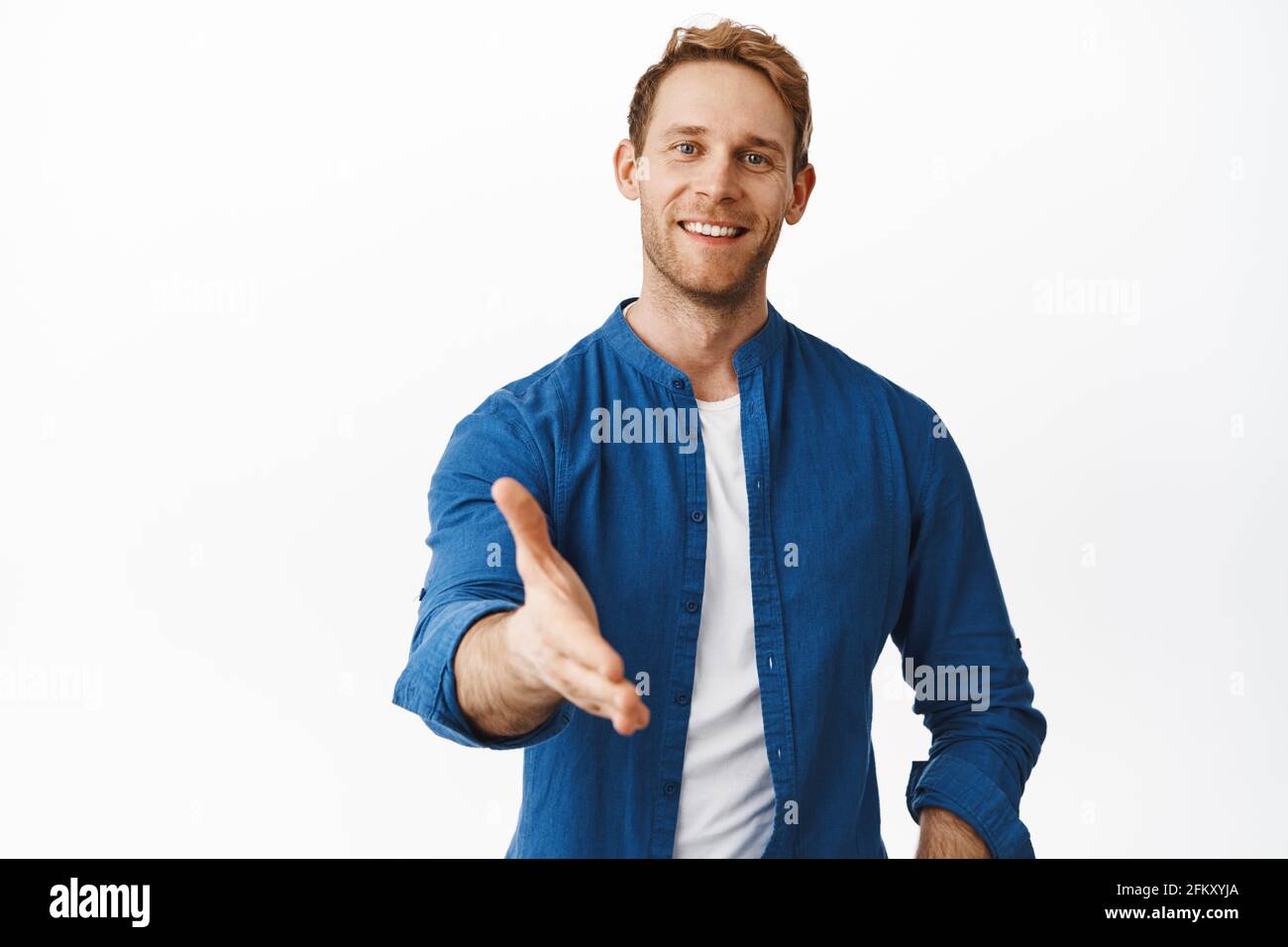 Hello nice to meet you. Smiling handsome redhead man extend hand for ...