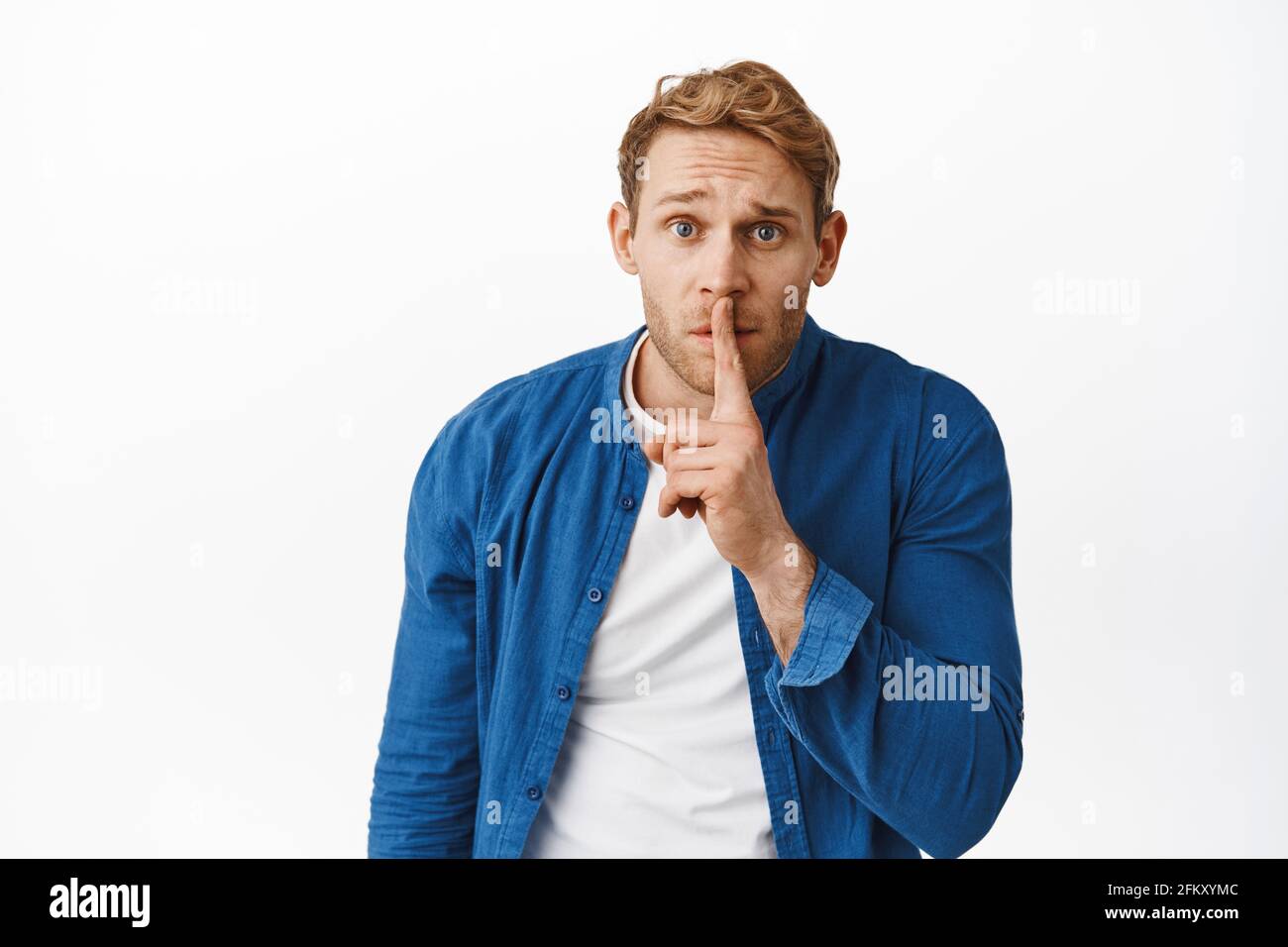 Worried redhead man asking to keep quiet, have secret, shushing with ...