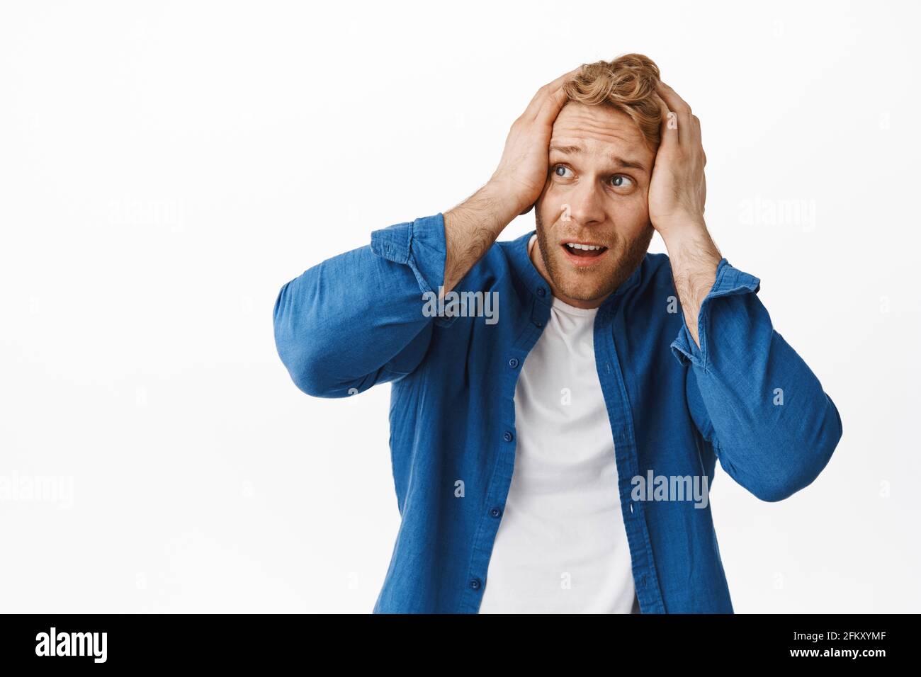 Troubled and anxious redhead man cover his head with hands and looking ...