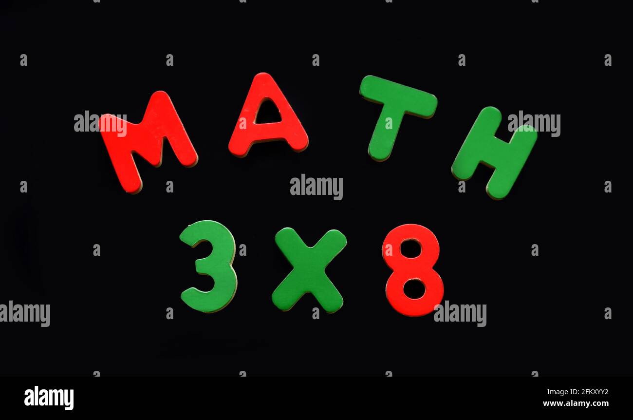 Wooden letters spell math and a multiplication problem on a black ...