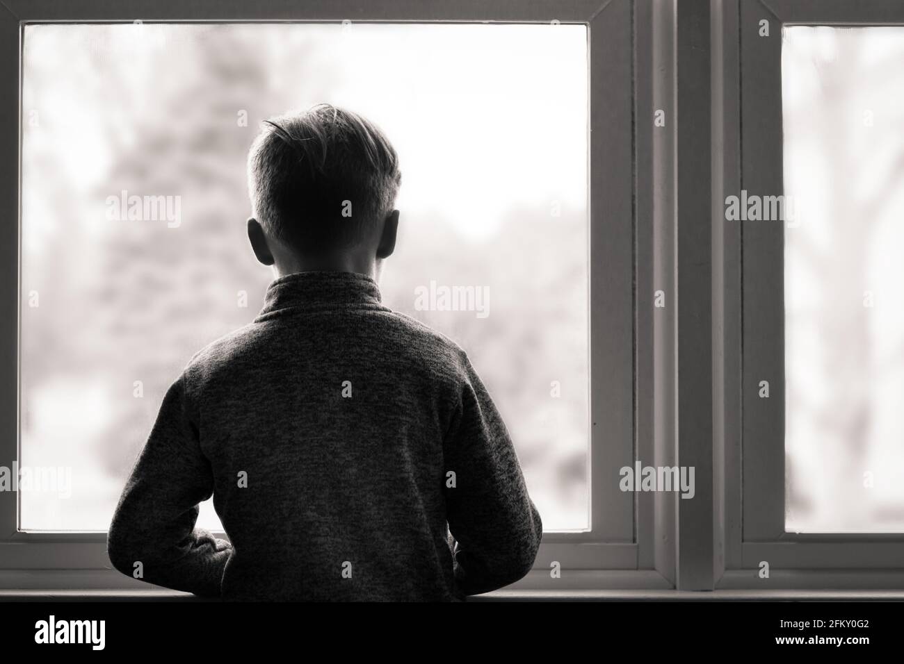 Boy looking out window sad hi-res stock photography and images - Alamy