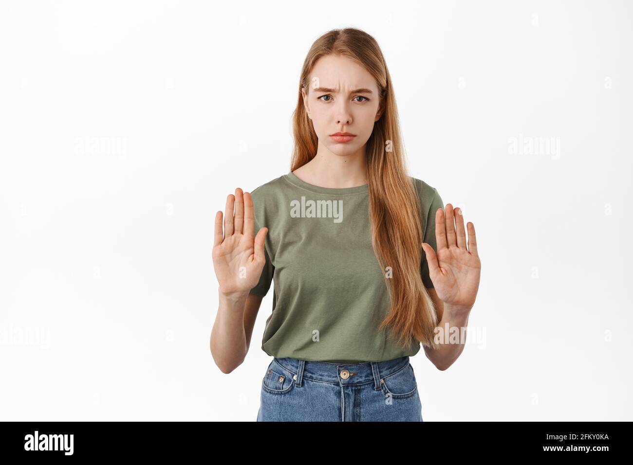 Stop. Serious girl raising hands to block, say no, disapprove action ...