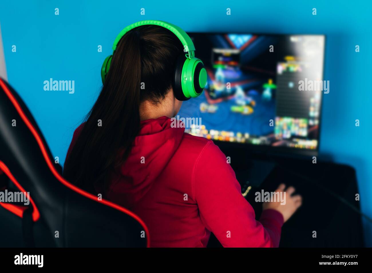The gamer sits on a gaming chair and plays computer games. The player ...