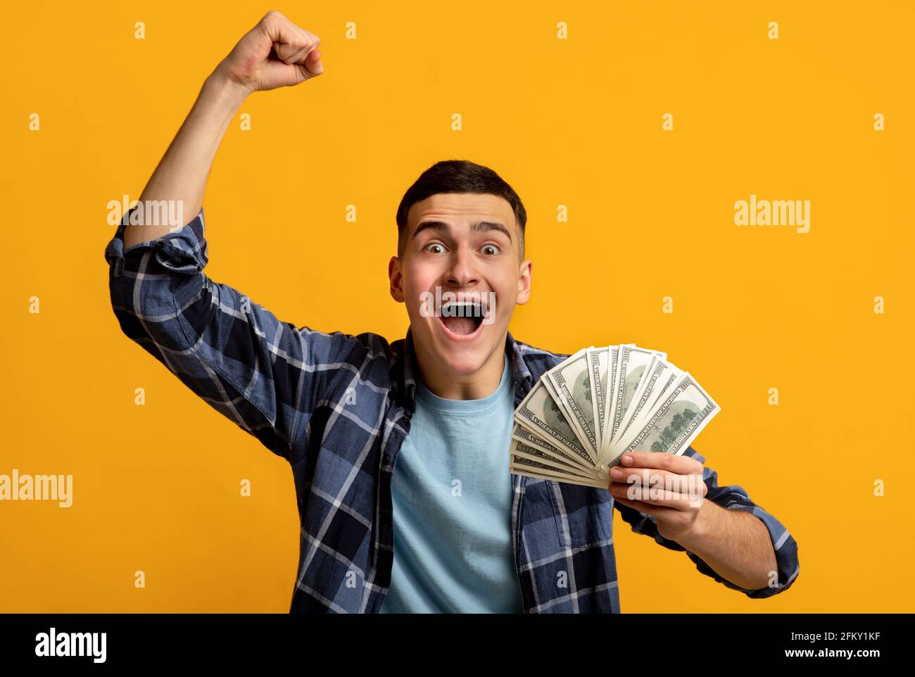 Overjoyed hipster guy holding lots of money, screaming WOW and making ...