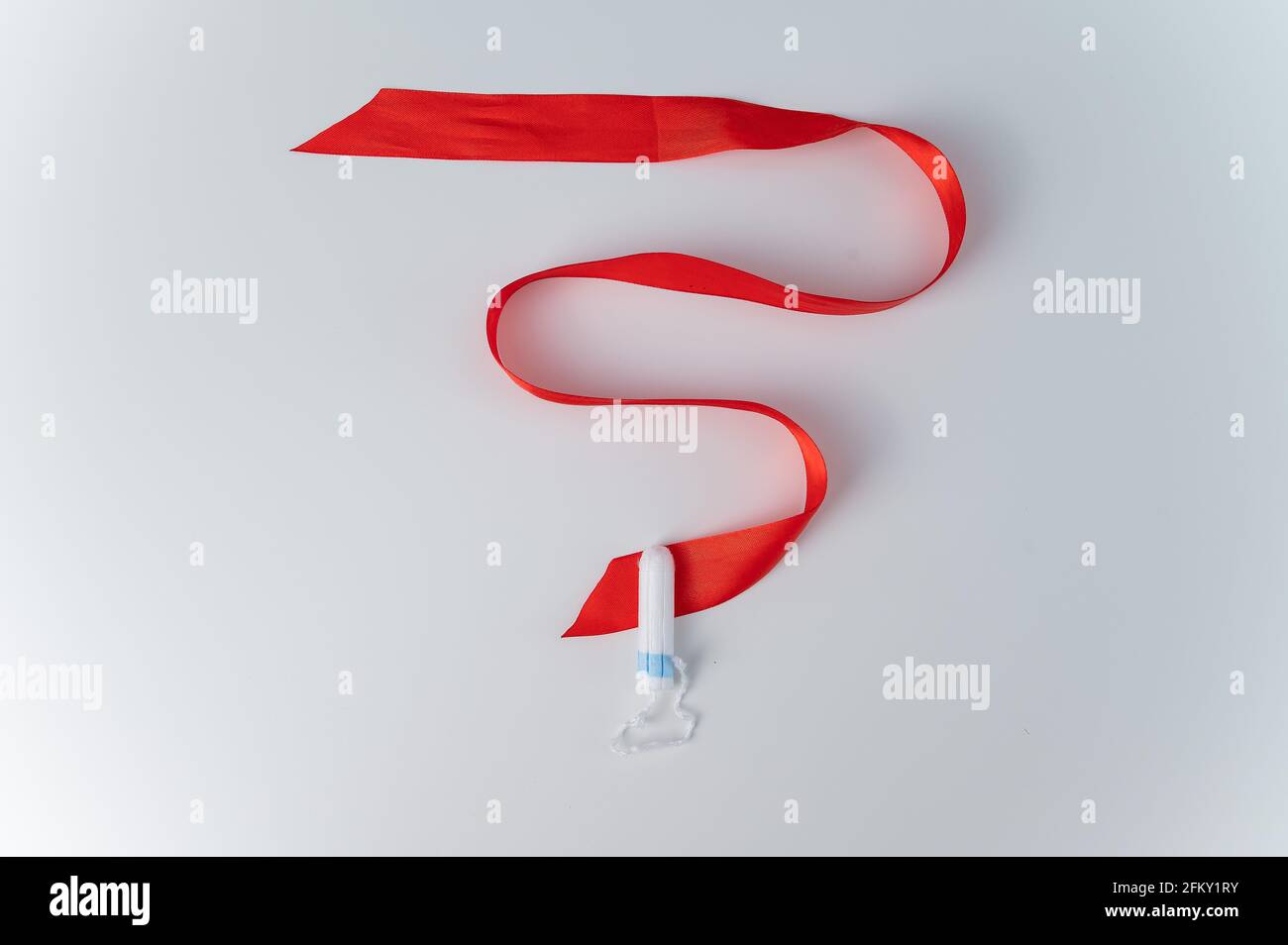 Tampon and red satin ribbon on a white background. Means of intimate ...