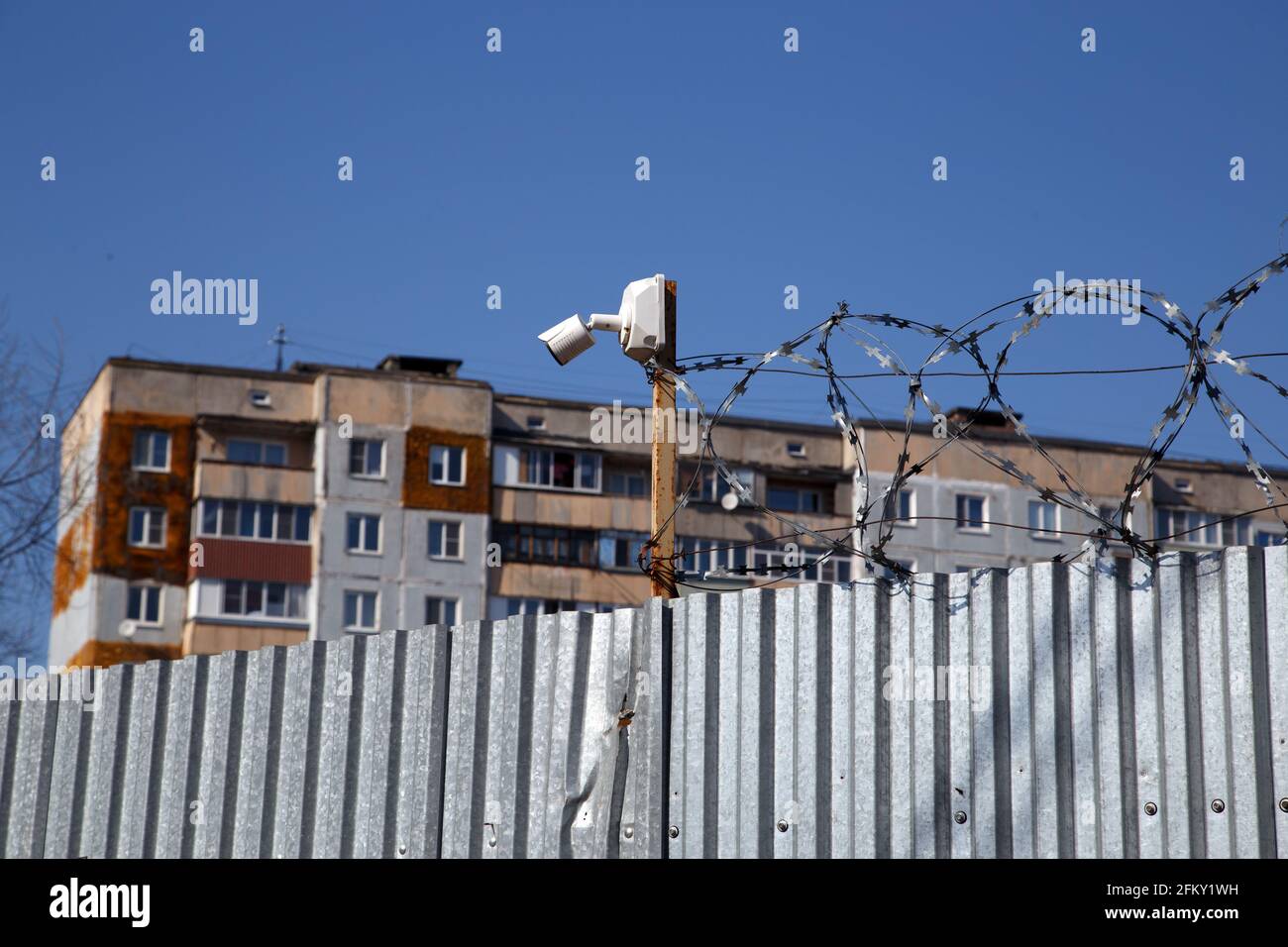 residential multi-storey building behind a fence with barbed wire and ...