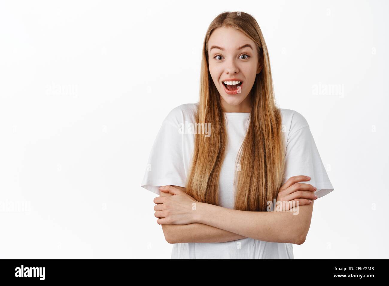 Image of surprised blond girl, gasping amazed, raising eyebrows excited ...