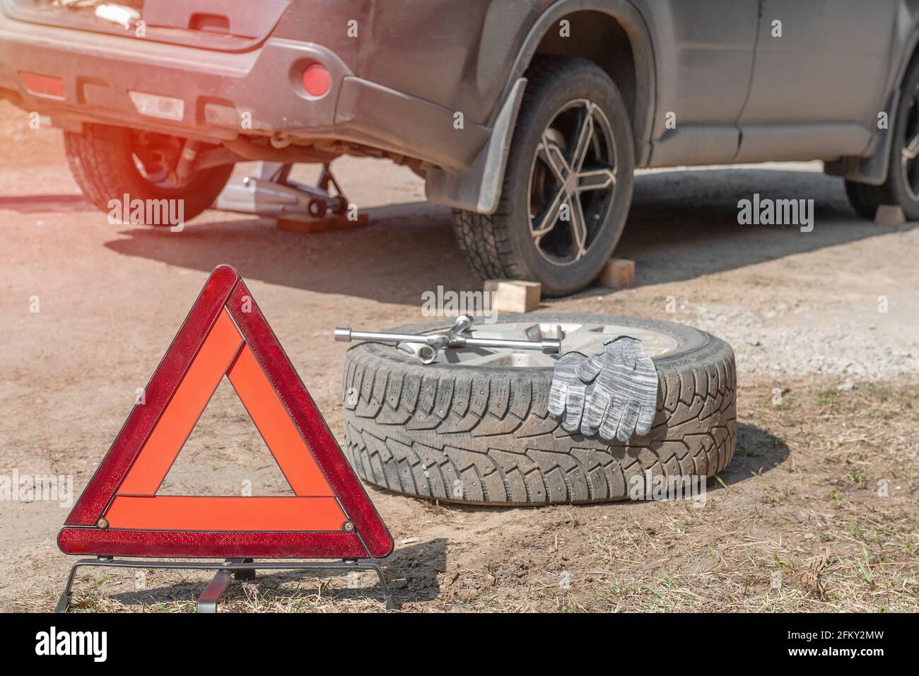 Stop sign in front of the car. Replacing the wheel on the road by the ...