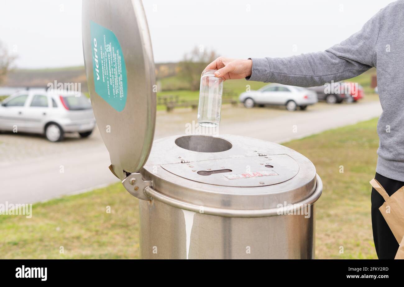Man's hand with glass bottle in glass tank for recycling. Social ...