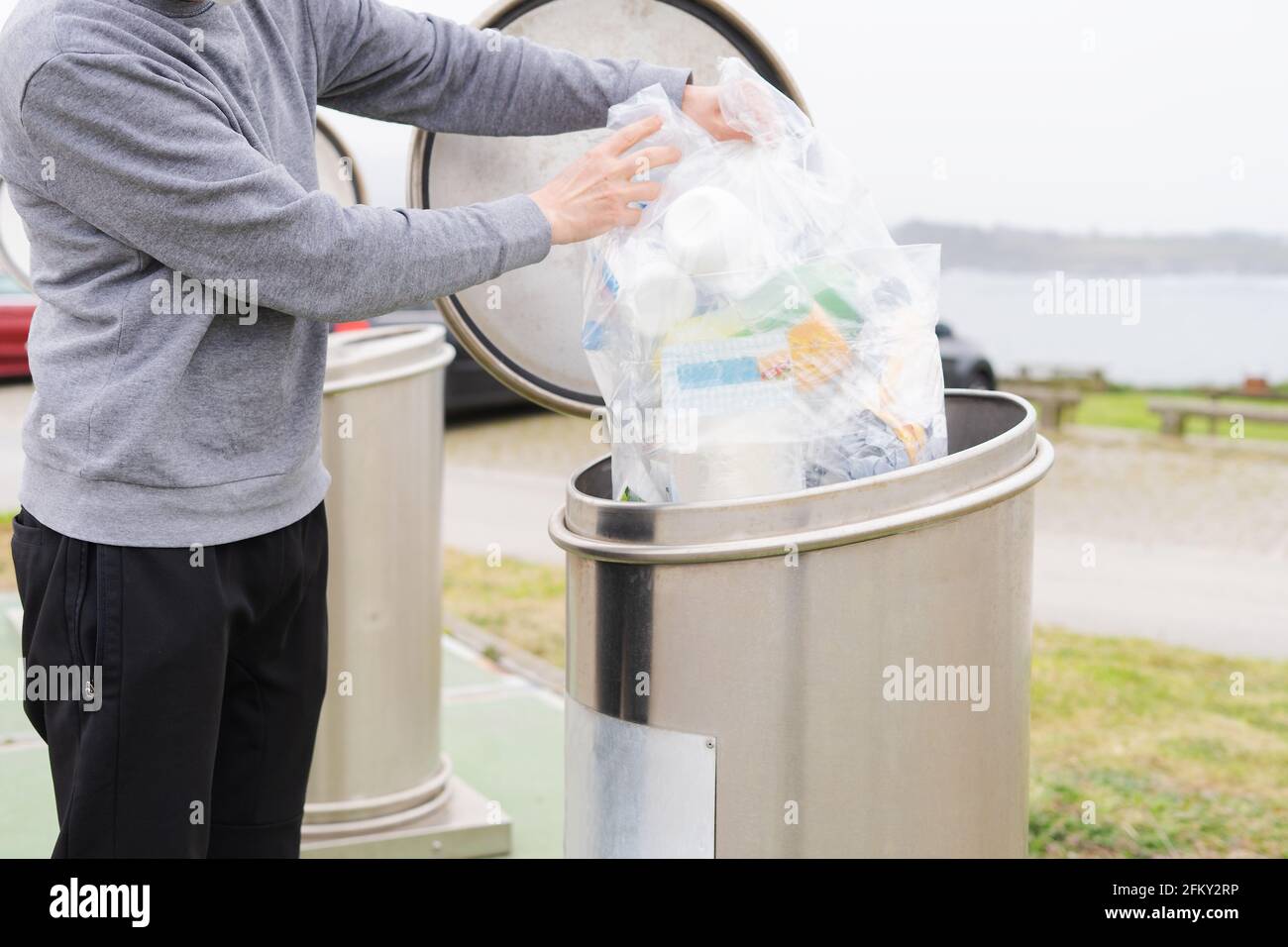 Man throwing plastic containers at plastic recycling point. Social ...