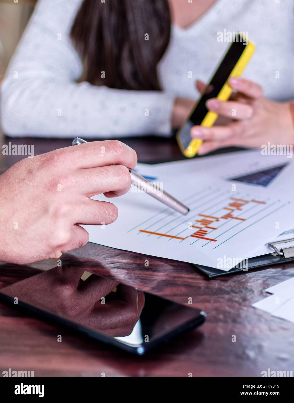 Vertical shot of coworkers discussing results in chart and graph work ...