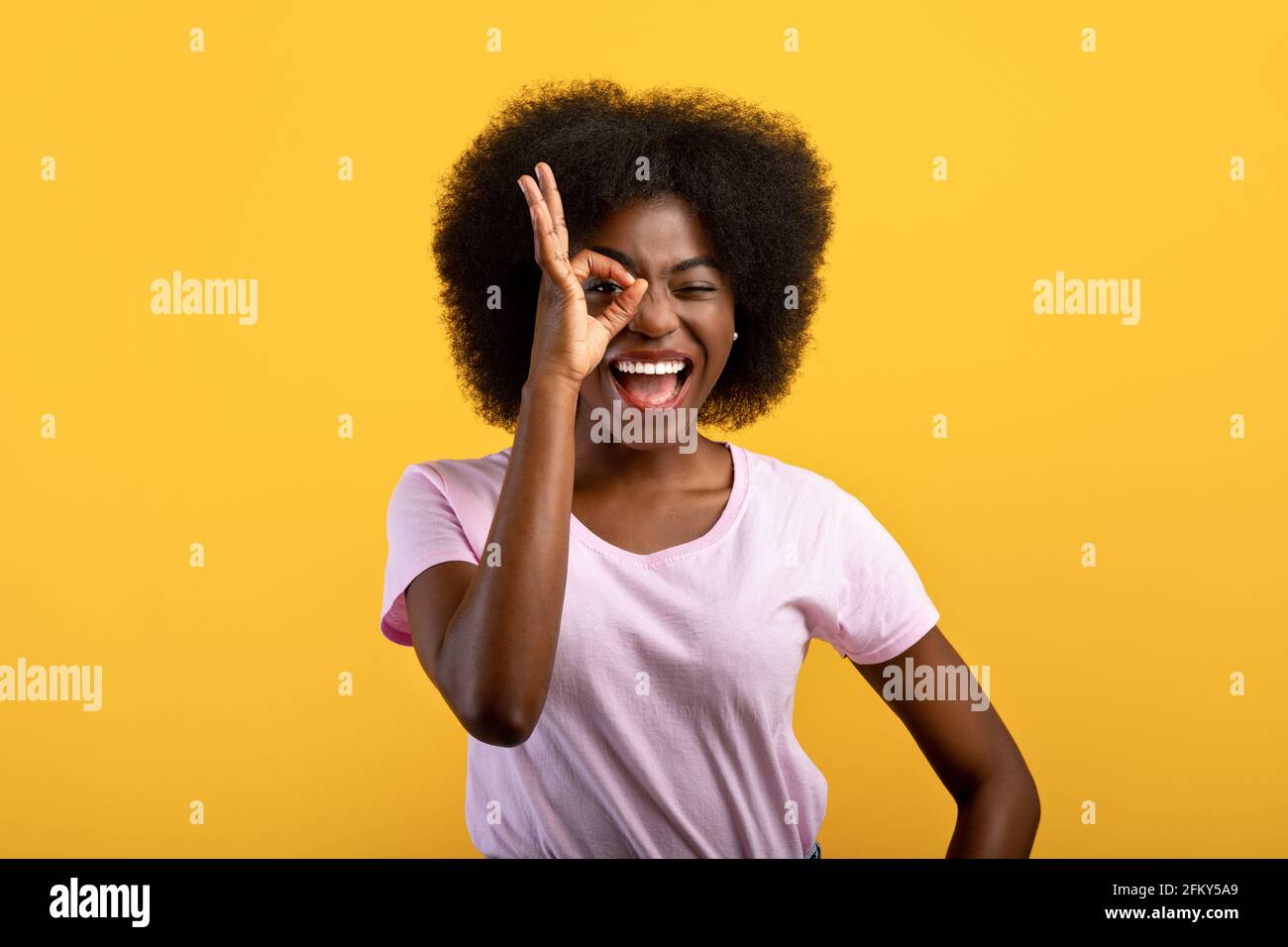 All is ok. Positive african american lady looking through okay sign ...