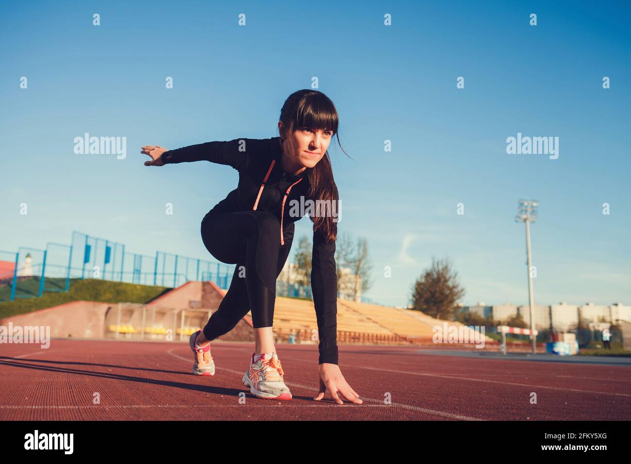Sportswoman in starting position ready for running. Female athlete ...