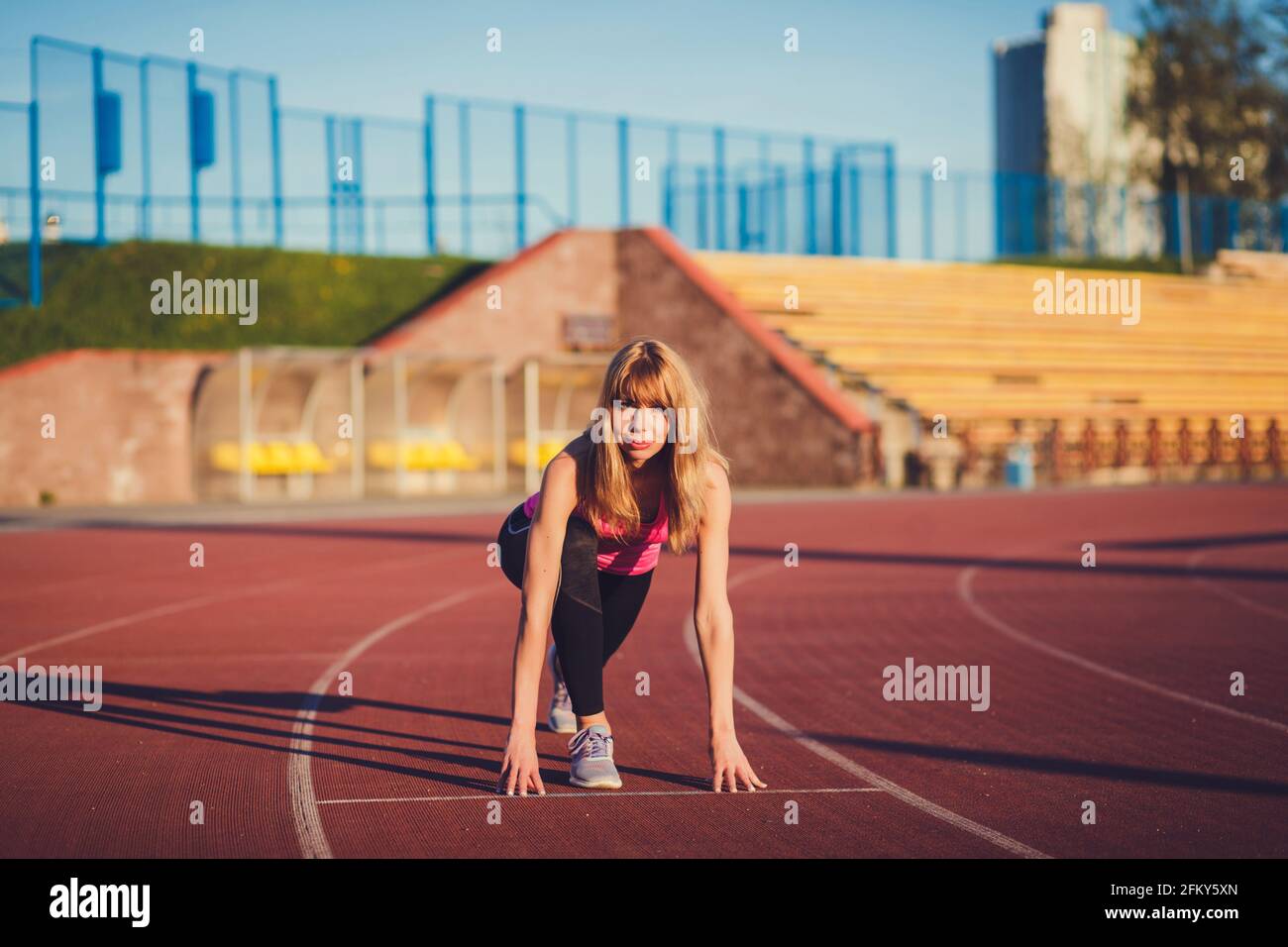 Confident woman in starting position ready for running. Female athlete ...