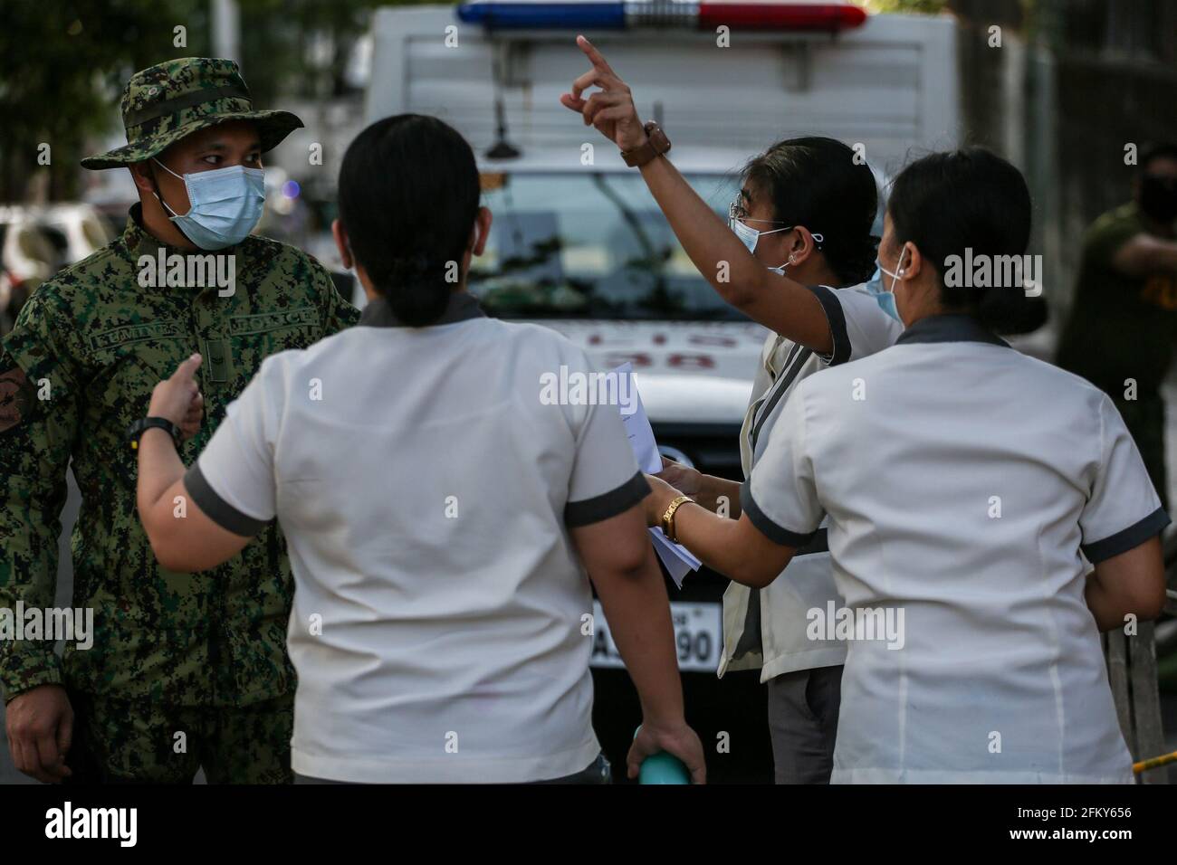 Policemen stop people from entering a checkpoint near a village during ...
