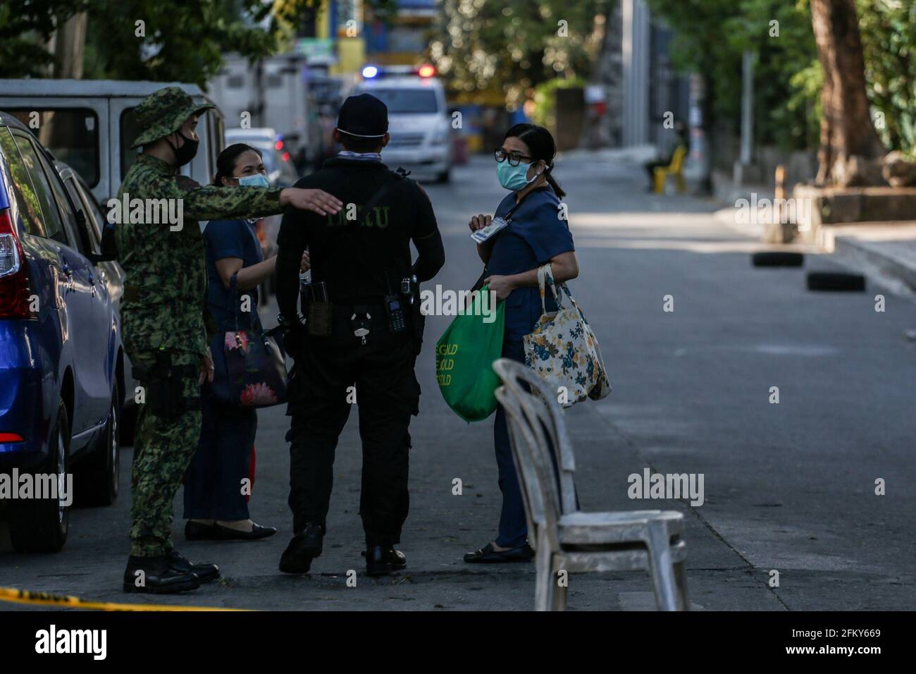 Policemen stop people from entering a checkpoint near a village during ...