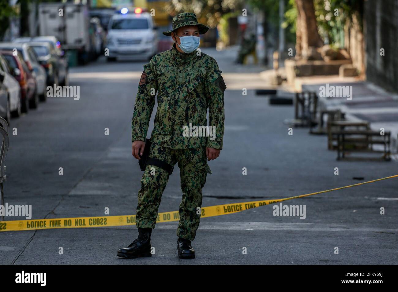 A policeman wearing a protective mask stands guard at a checkpoint in ...