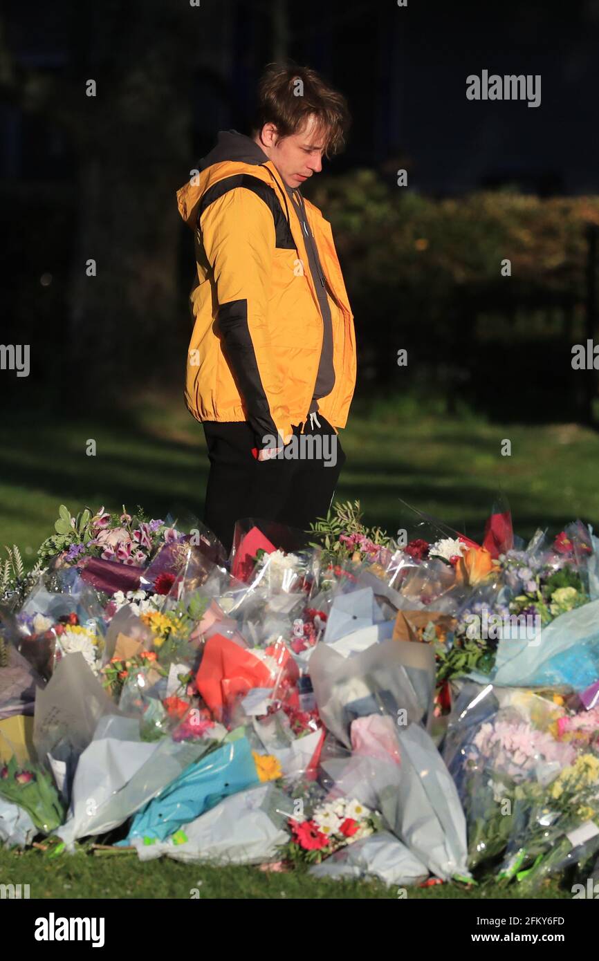 Patrick James, the son of PCSO Julia James, looks at floral tributes ...