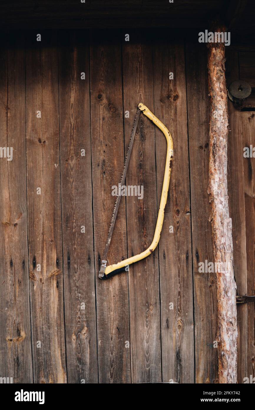 detail of old metal saw hanging in front of wooden wall Stock Photo - Alamy
