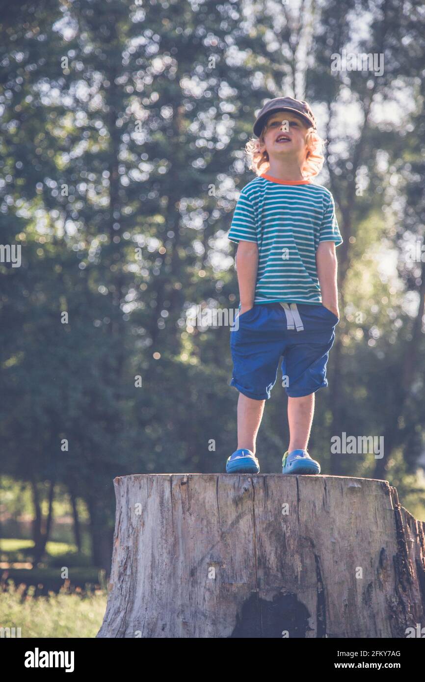 Young Boy Stood on a tree trunk doing different expressions Stock Photo ...