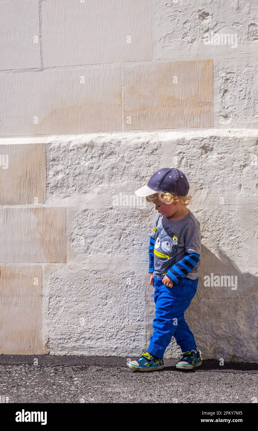 Young Blond hair boy stood against white wall Stock Photo - Alamy