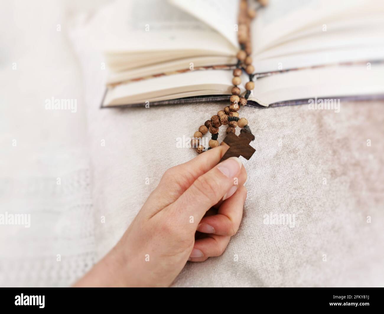 Female hand holding a wooden cross necklace Stock Photo - Alamy