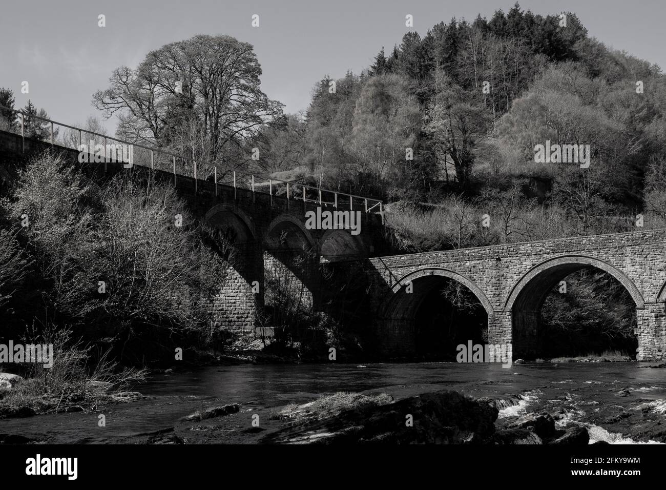a black and white photo of the bridges at Berwyn going over the river ...