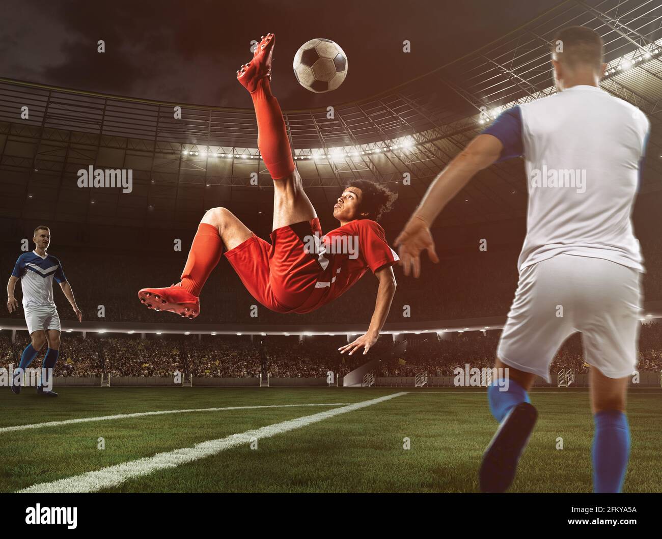 Soccer striker in red uniform hits the ball with an acrobatic kick in ...
