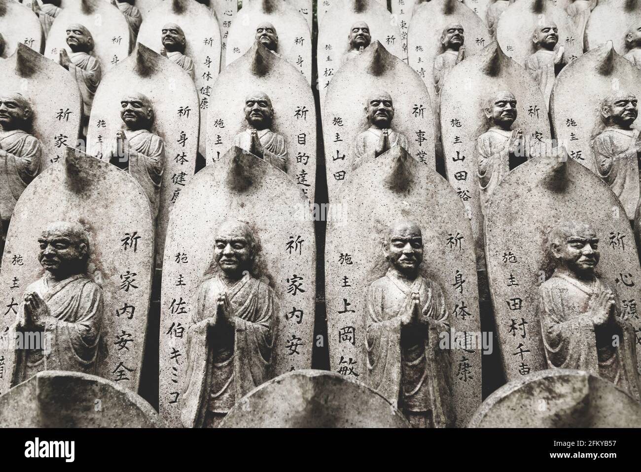 Stone buddhist statues with japanese text in a line at the Daisho-in ...