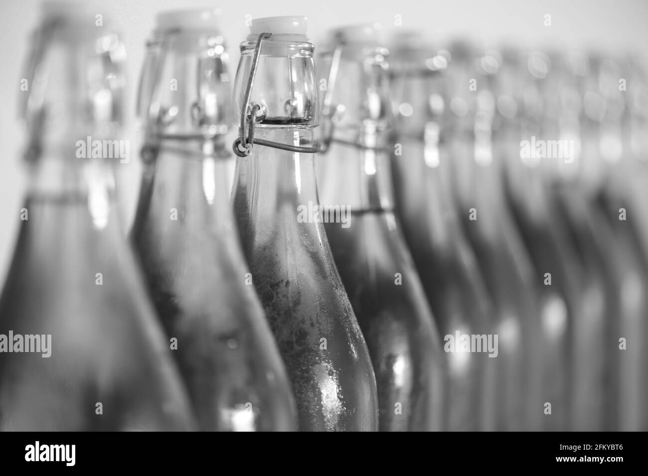 Black and white photo of a row of flip top bottles of home made cider ...