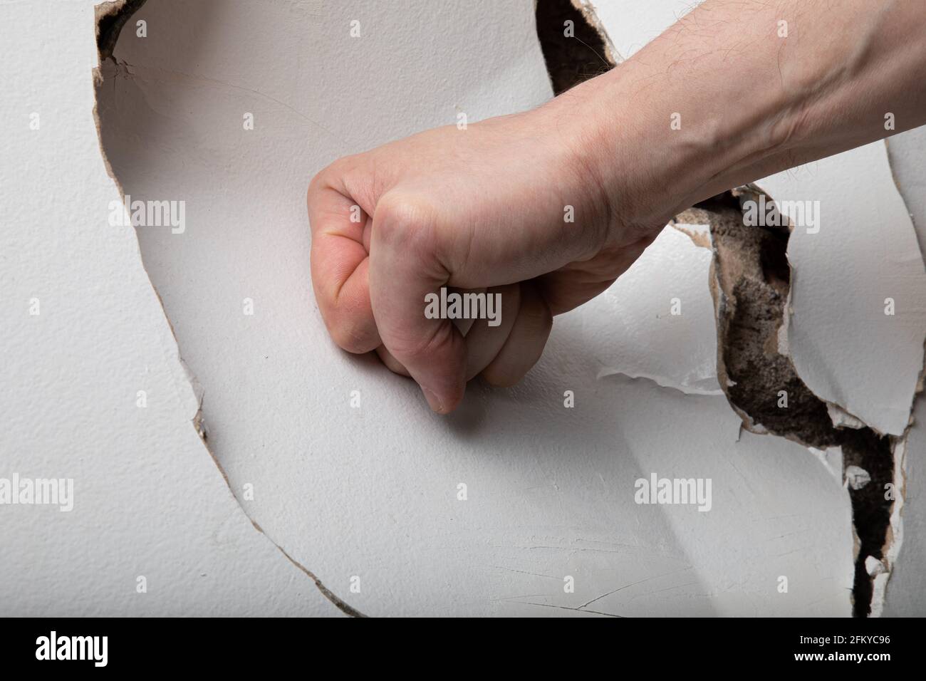 The angry man hits the wall and breaks it Stock Photo - Alamy