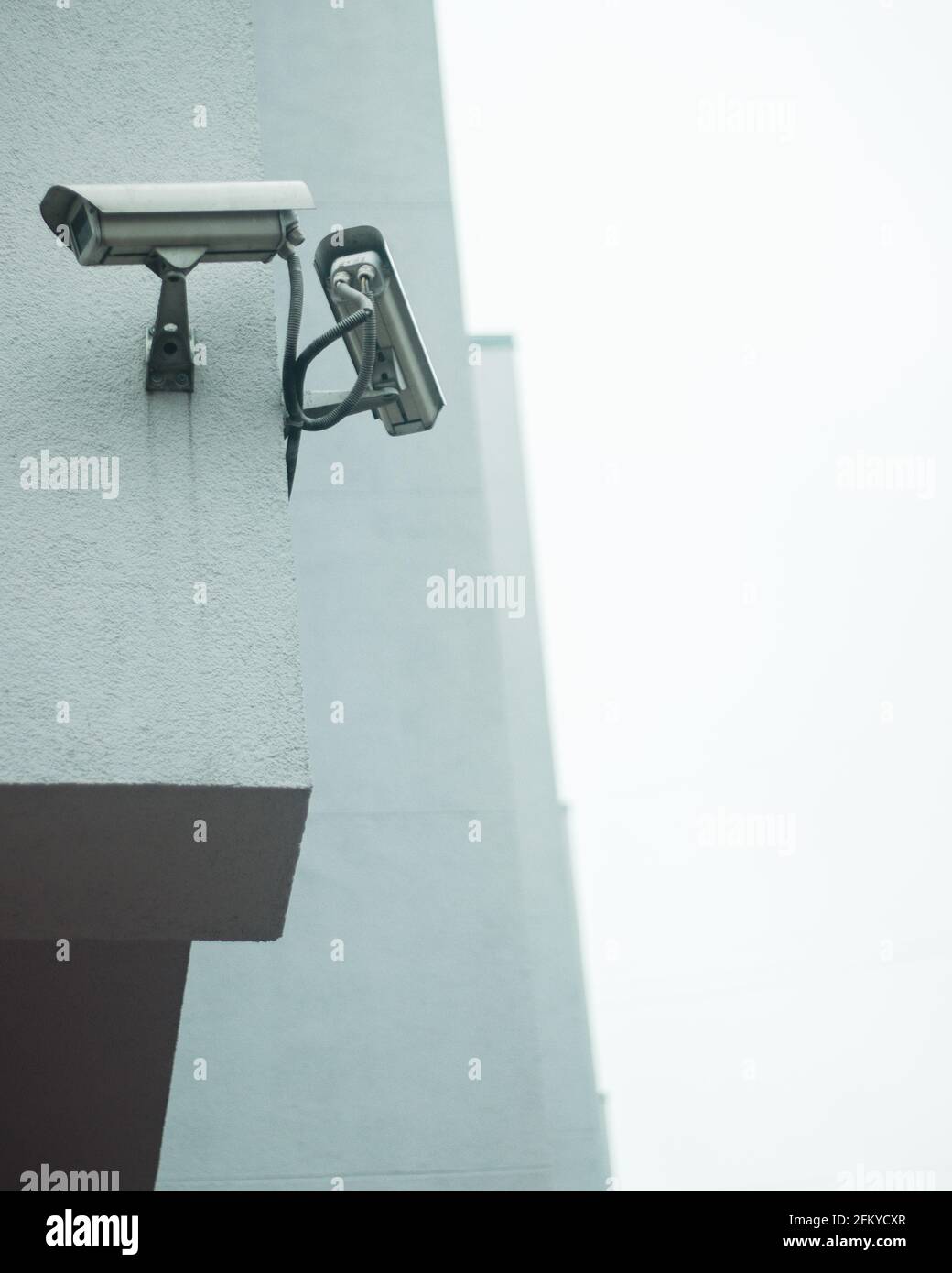 Vertical shot of security cameras on the white building wall Stock ...