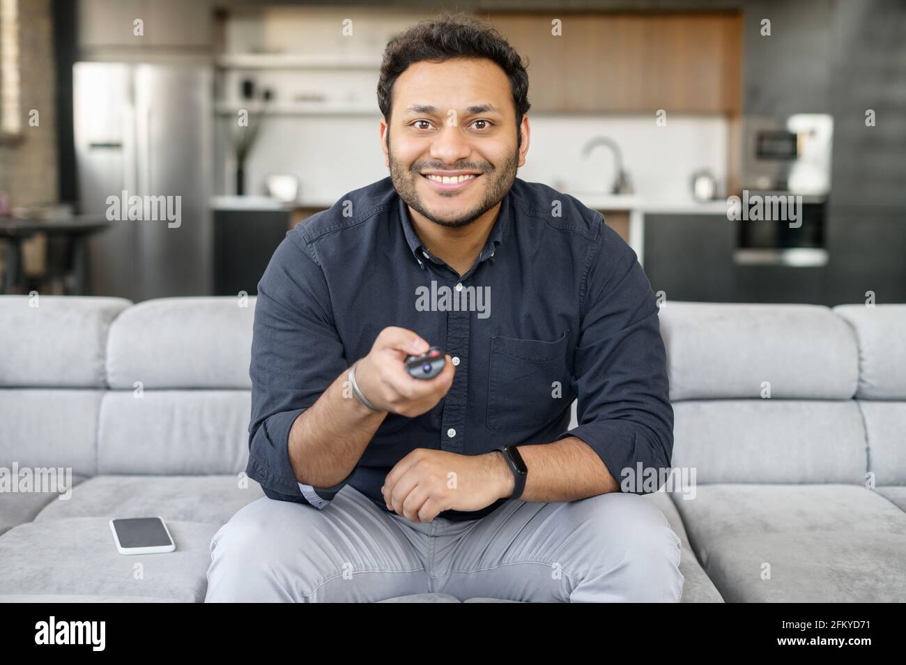 Indian man watching tv smiling hi-res stock photography and images - Alamy