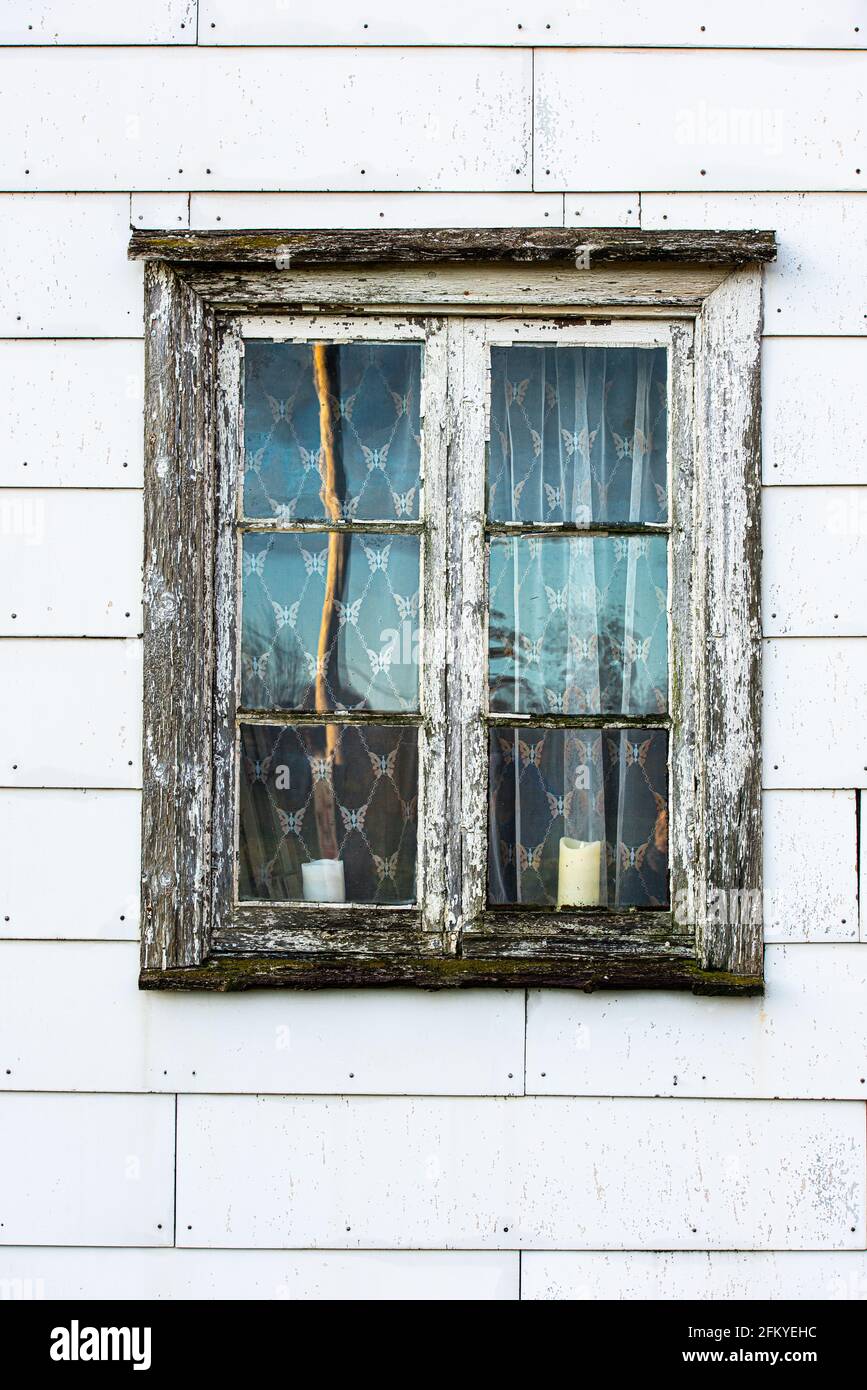 Broken windows of an old, abandoned house with asbestos wall tiles ...