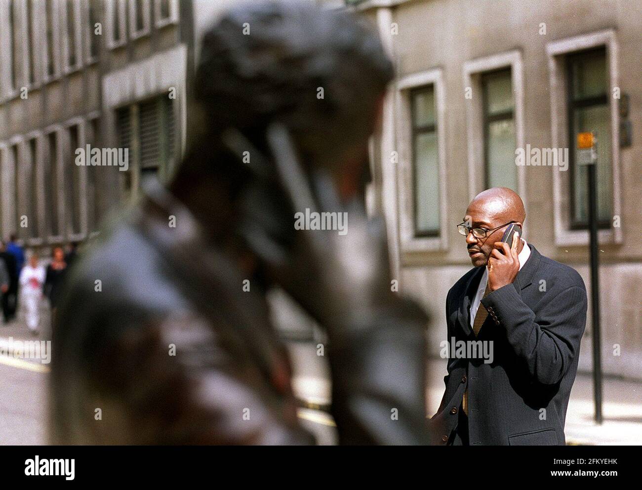 A BUSINESSMAN/BROKER MAKES A CALL NEAR A STATUE OF A LIFFE TRADER ...