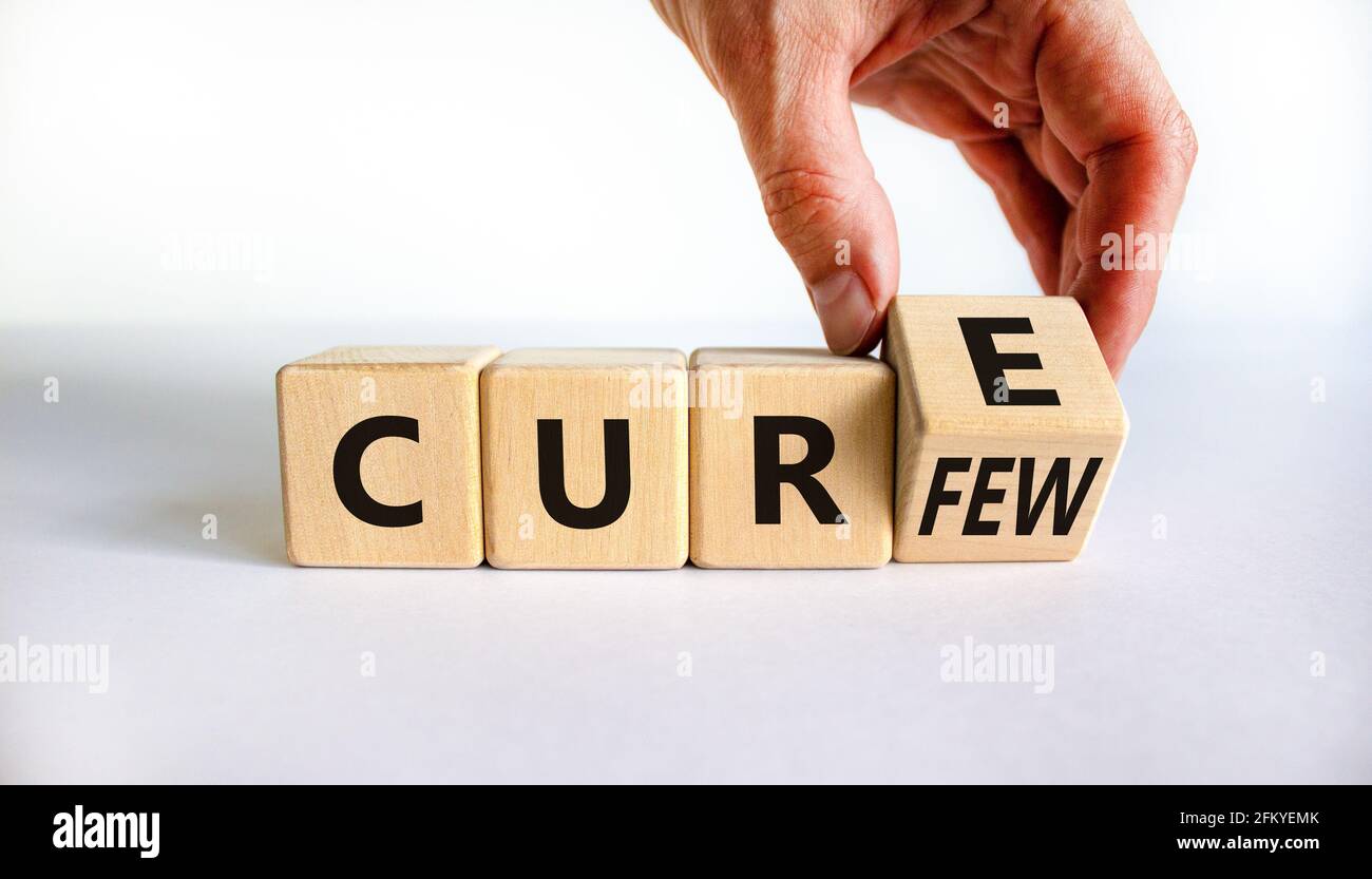 Curfew and cure symbol. Businessman turns a cube and changes the word ...