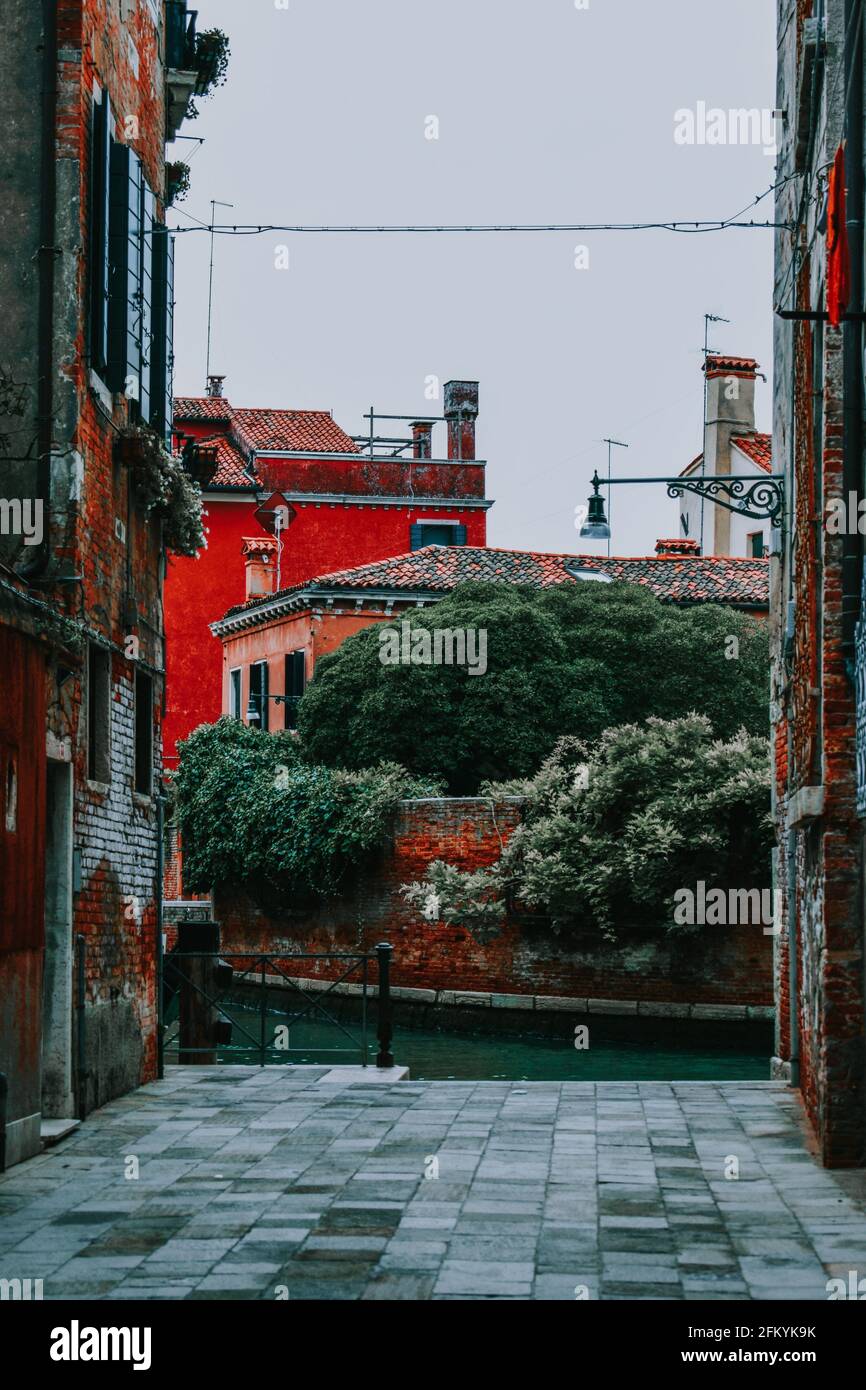 Vertical shot of an alley of old houses under a cloudy sky in the ...