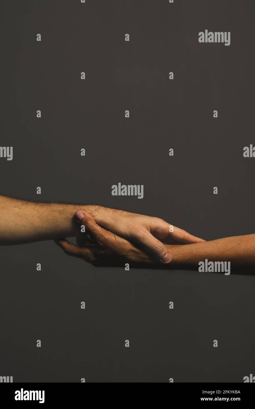 Vertical shot of a pair of hands gripping each other's wrists in a ...