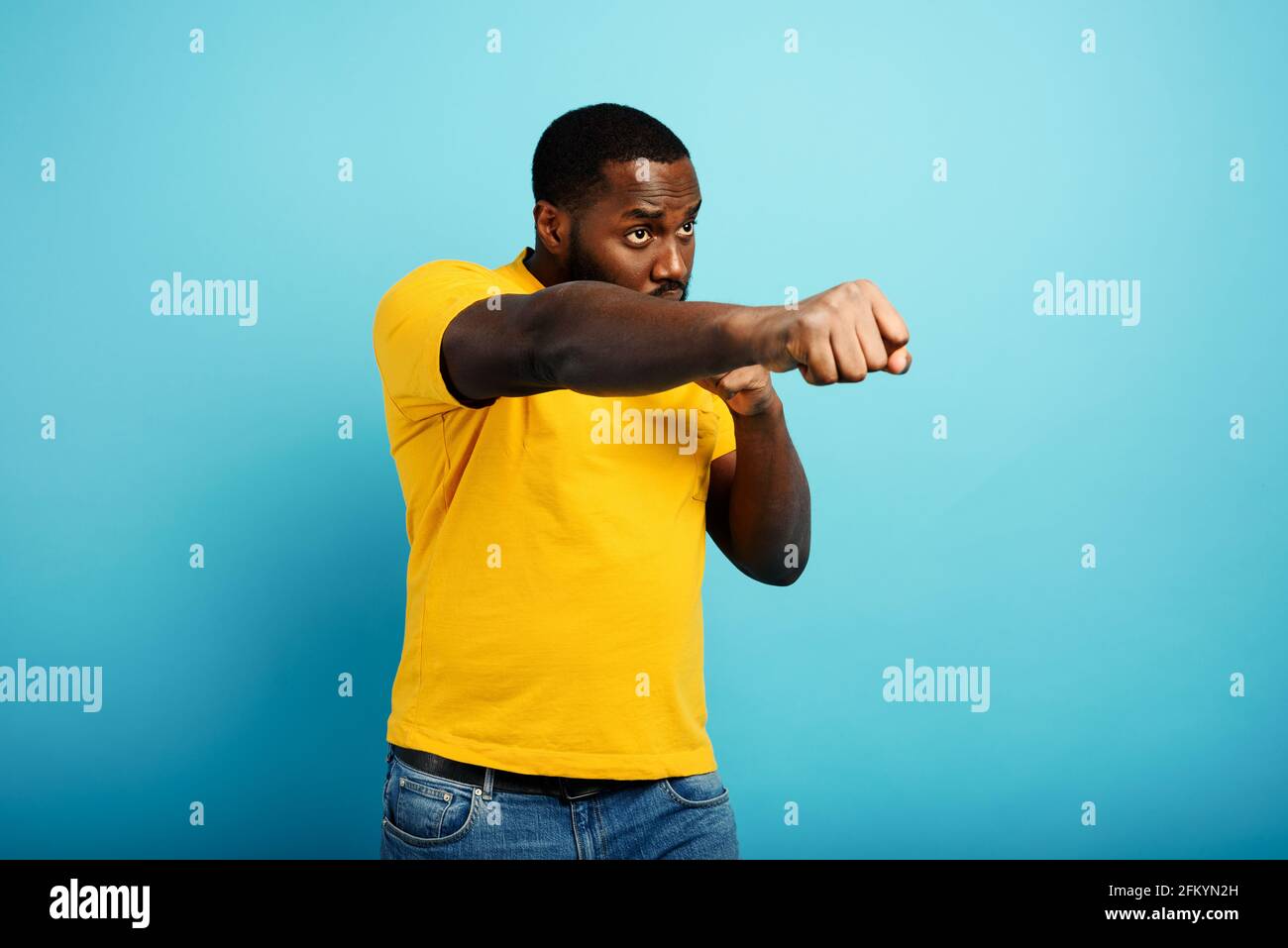 Black man punches and fight against something. cyan background Stock ...