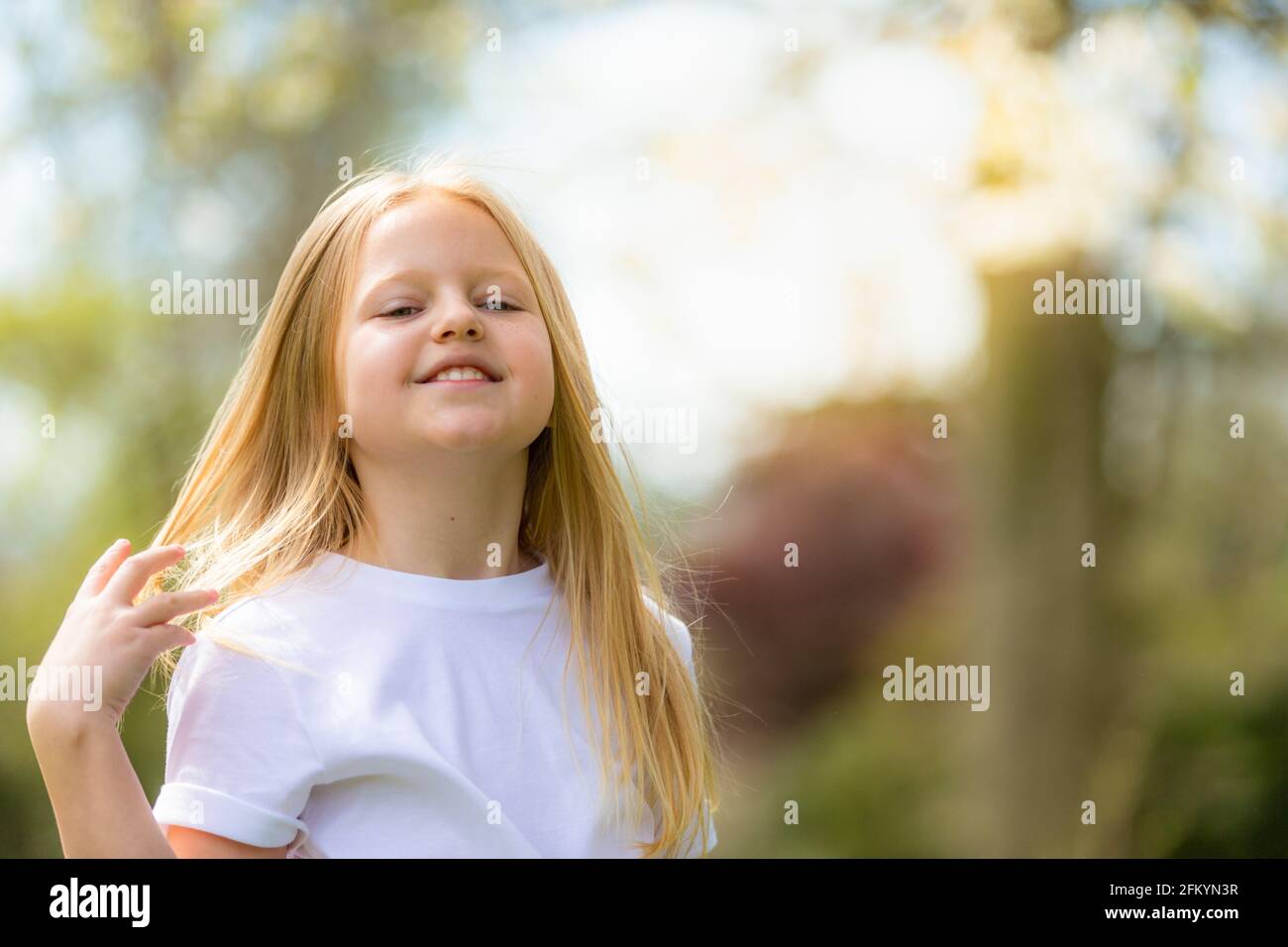 Pretty eight year old girl outside in the sunshine smiling Stock Photo ...