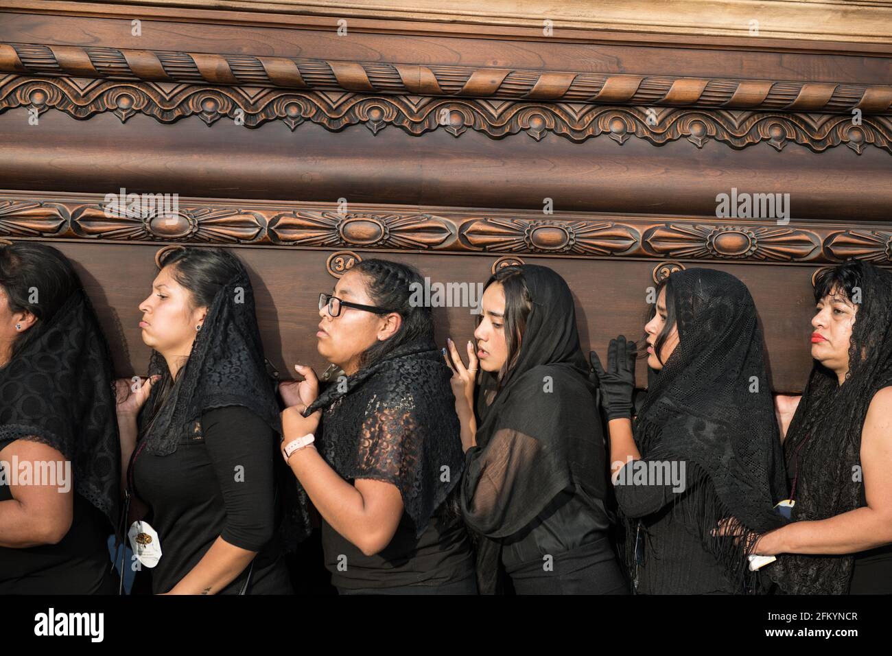 Women carry an elaborate wooden float (anda) during the Semana Santa ...