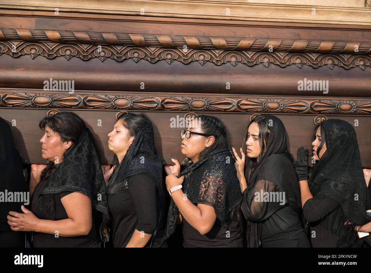 Women carry an elaborate wooden float (anda) during the Semana Santa ...
