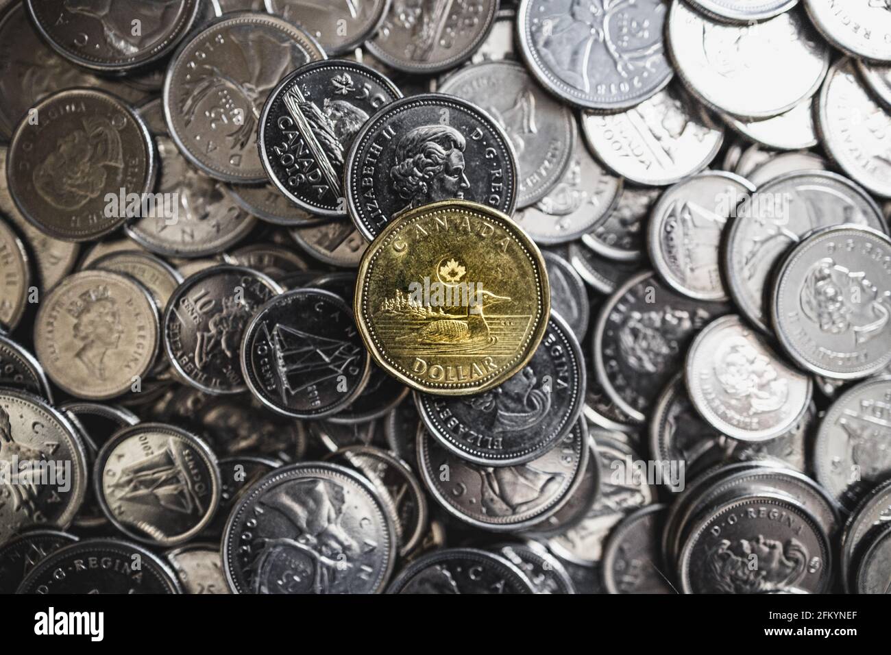 Horizontal background of silver shiny coins with a gold coin on the top ...