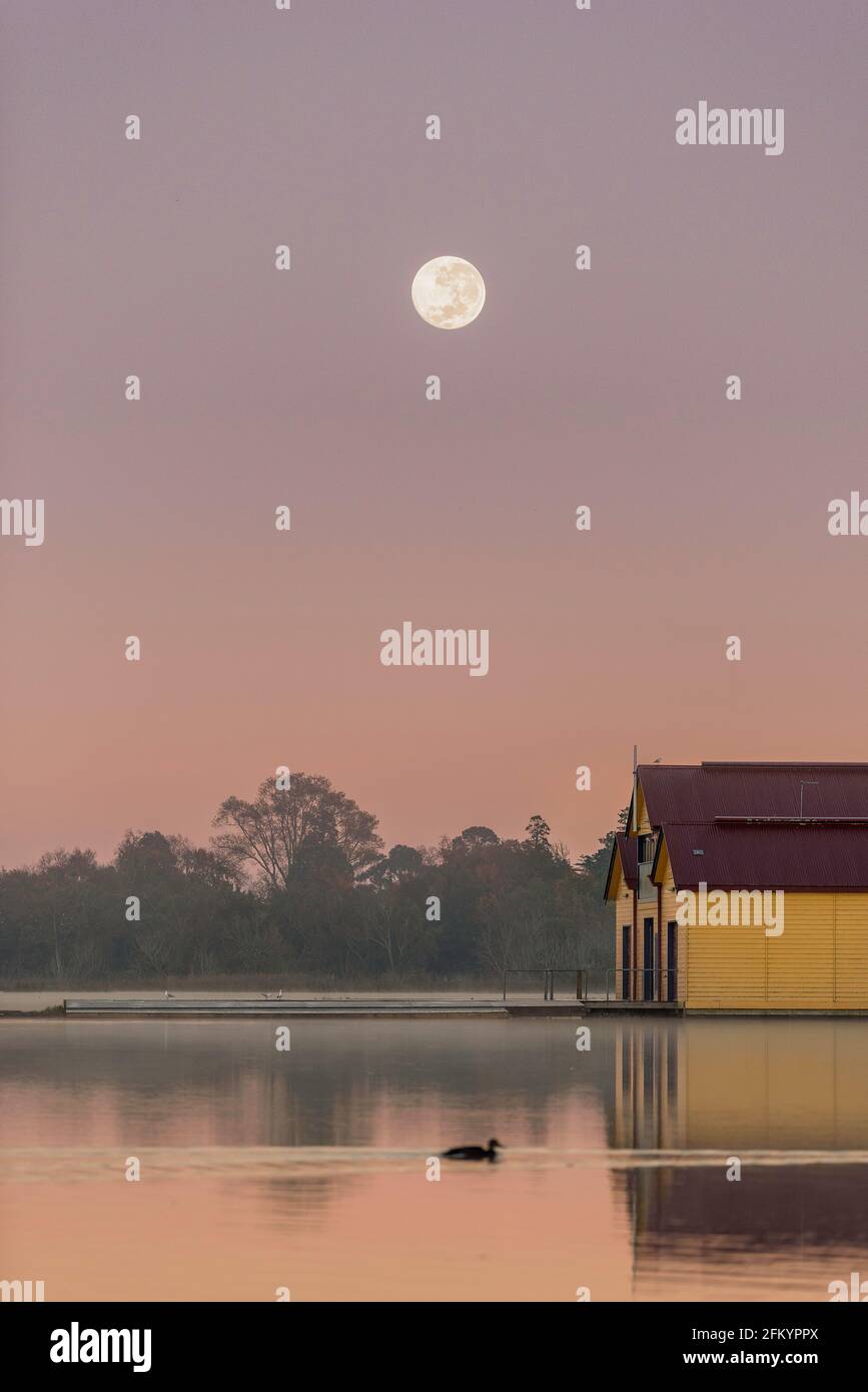 Full moon over lake sunrise Stock Photo - Alamy