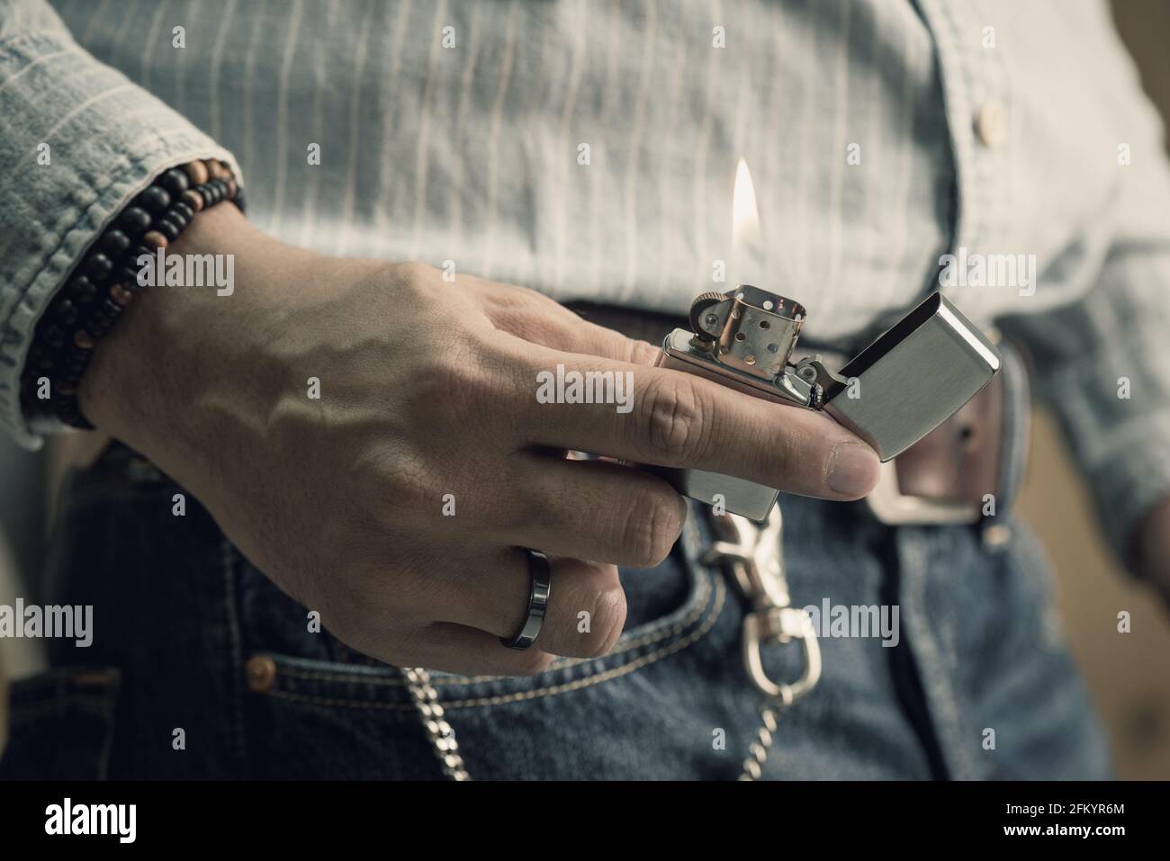 The man holding brushed chrome lighter with windproof in hand Stock ...